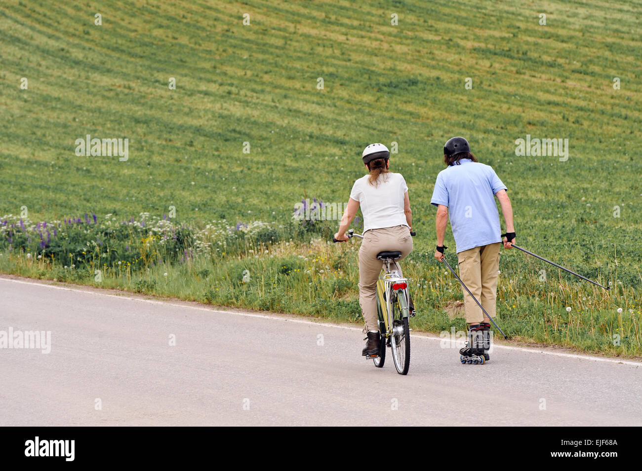 Senior couple vigorously exercising. The man is Nordic inline skating ...