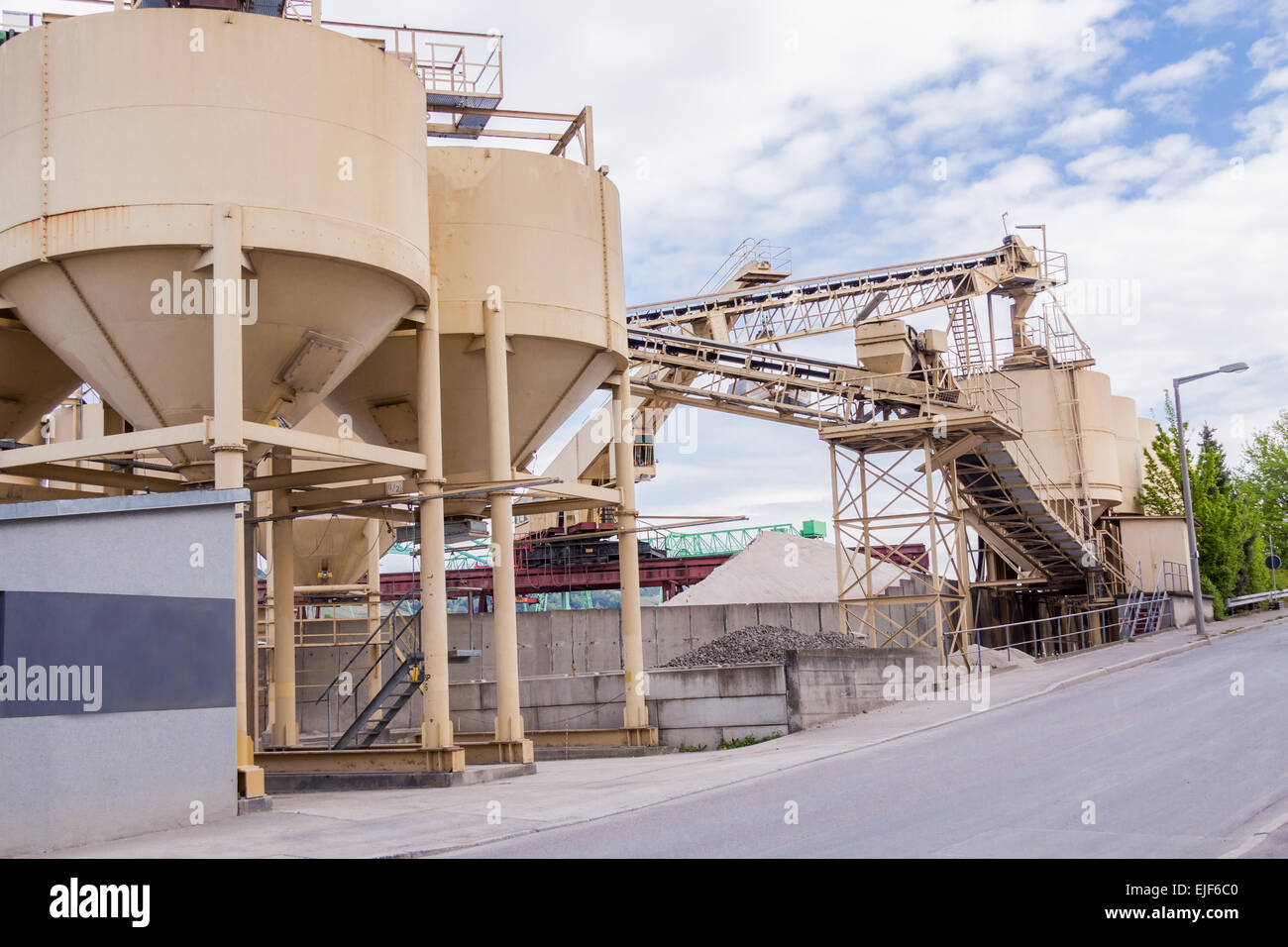 Row of large cylindrical metal tanks or silos at a refinery plant ...