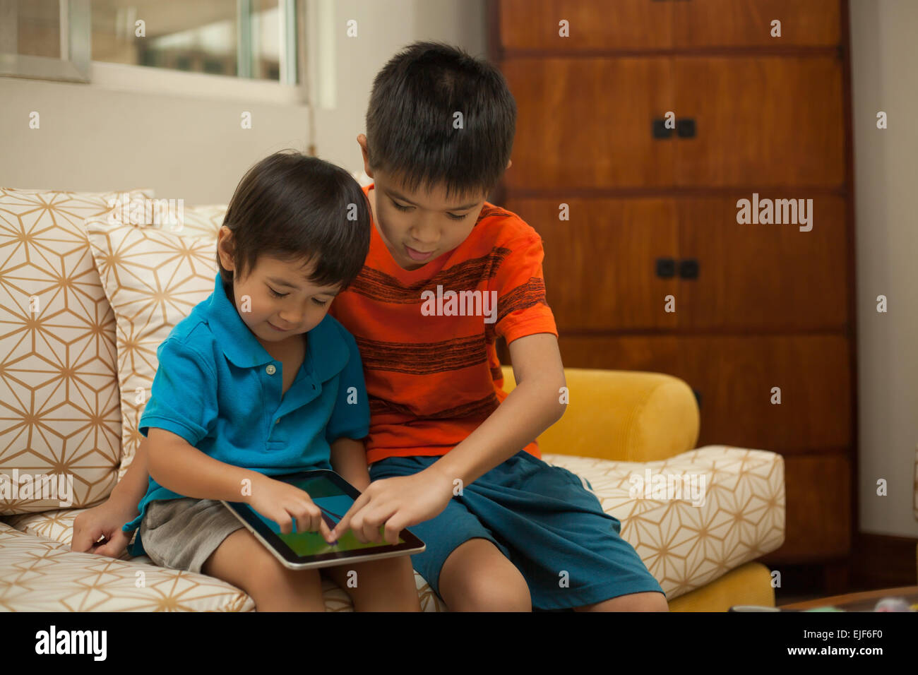 Two boys playing on a digital tablet Stock Photo - Alamy