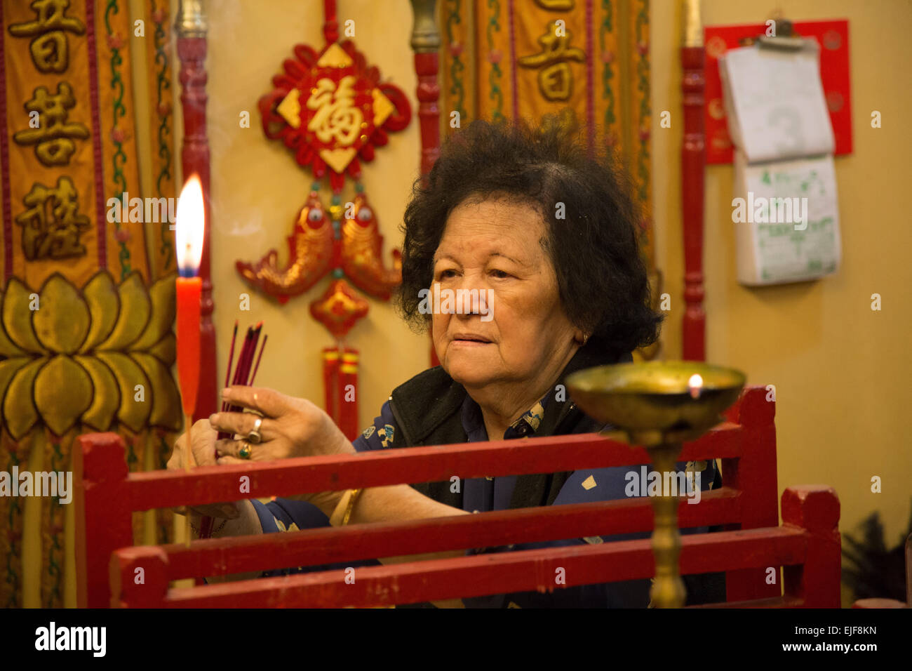 A Chinese woman worshiping in a temple Stock Photo - Alamy