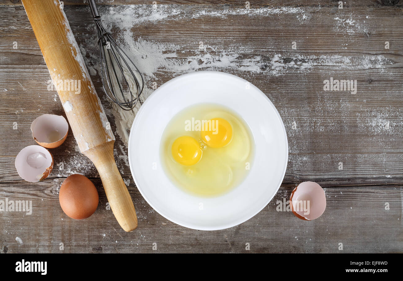 Cooking background with eggs, raw eggs in a dish, eggshells, flour ...