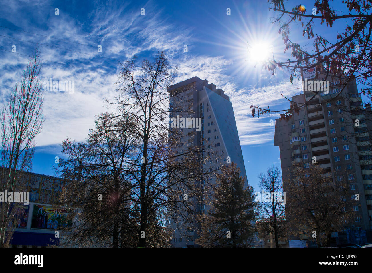 Sunset shines onto the nature of urban trees and high rise apartment ...