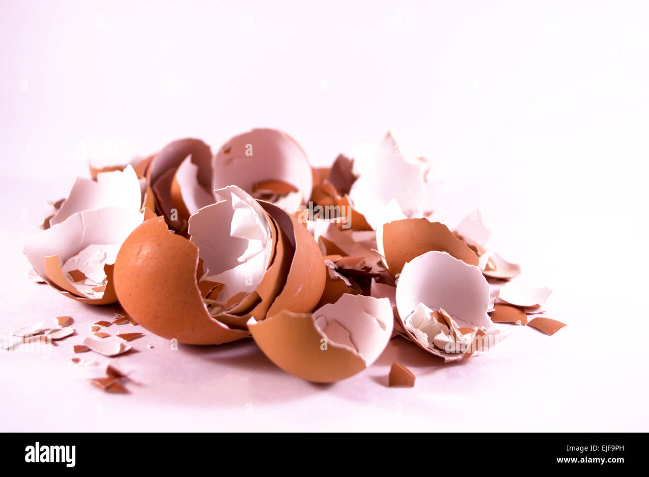 A pile of smashed crushed and broken eggshells on white background ...