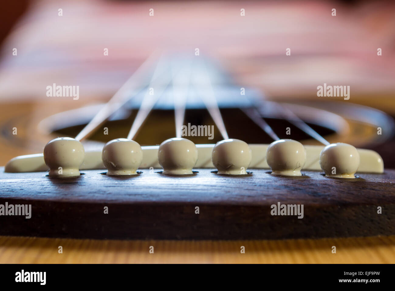 Guitar bridge and strings looking down the neck fretboard towards the ...