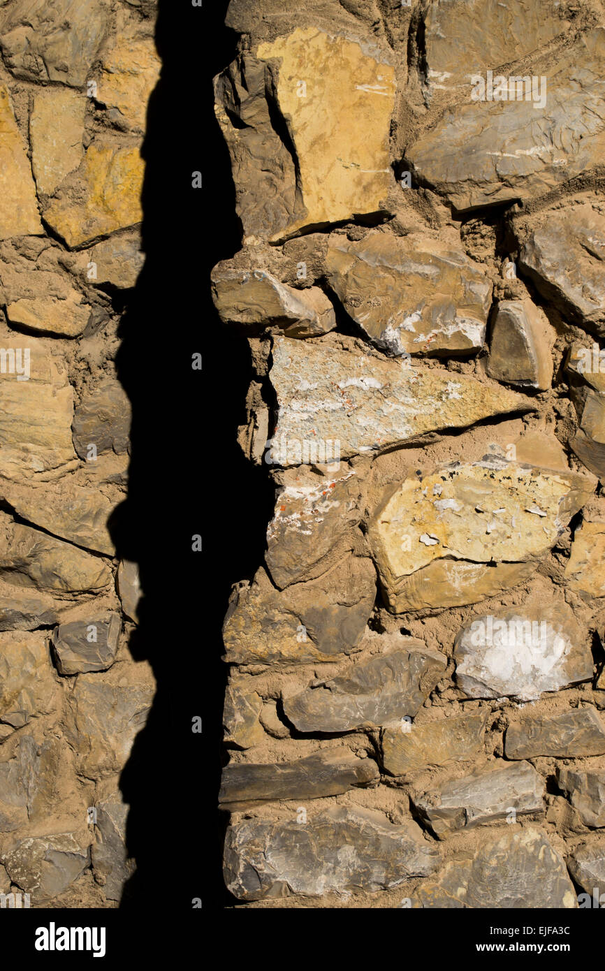 A crevice style shadow splits open a rock wall Stock Photo - Alamy