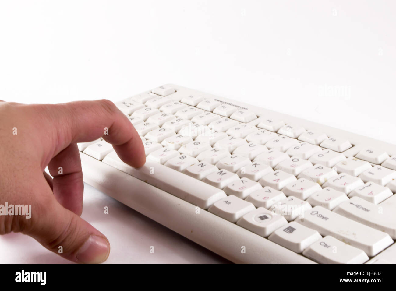 A male finger reaches to touch and press the space key on a keyboard ...