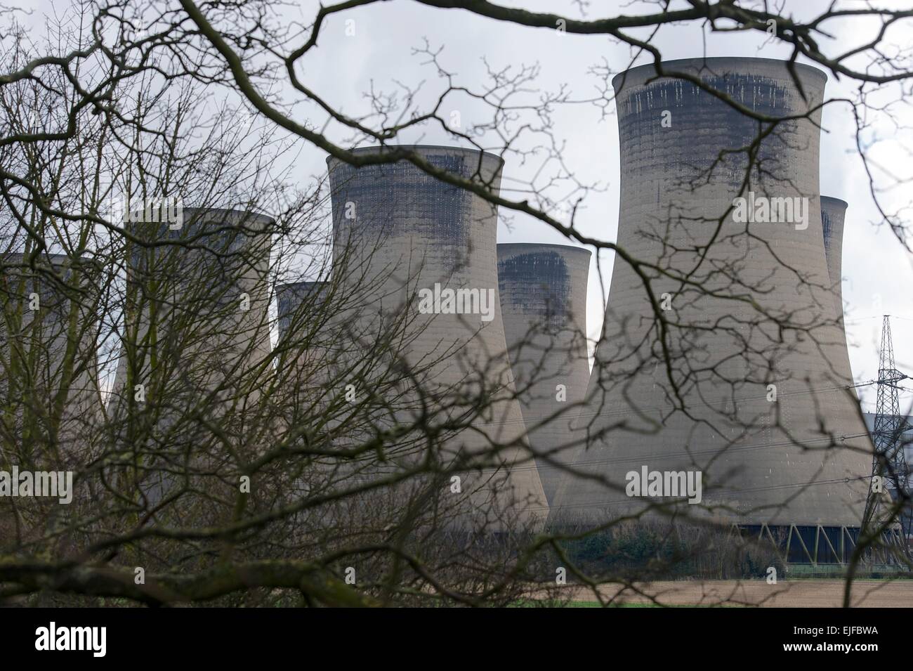 Cooling towers and electricity pylons against a bright cloudy sky at ...