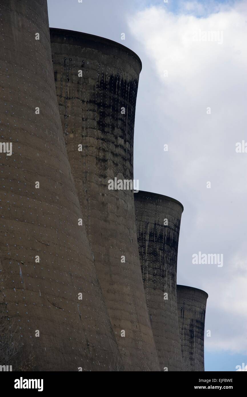 Cooling towers and electricity pylons against a bright cloudy sky at ...