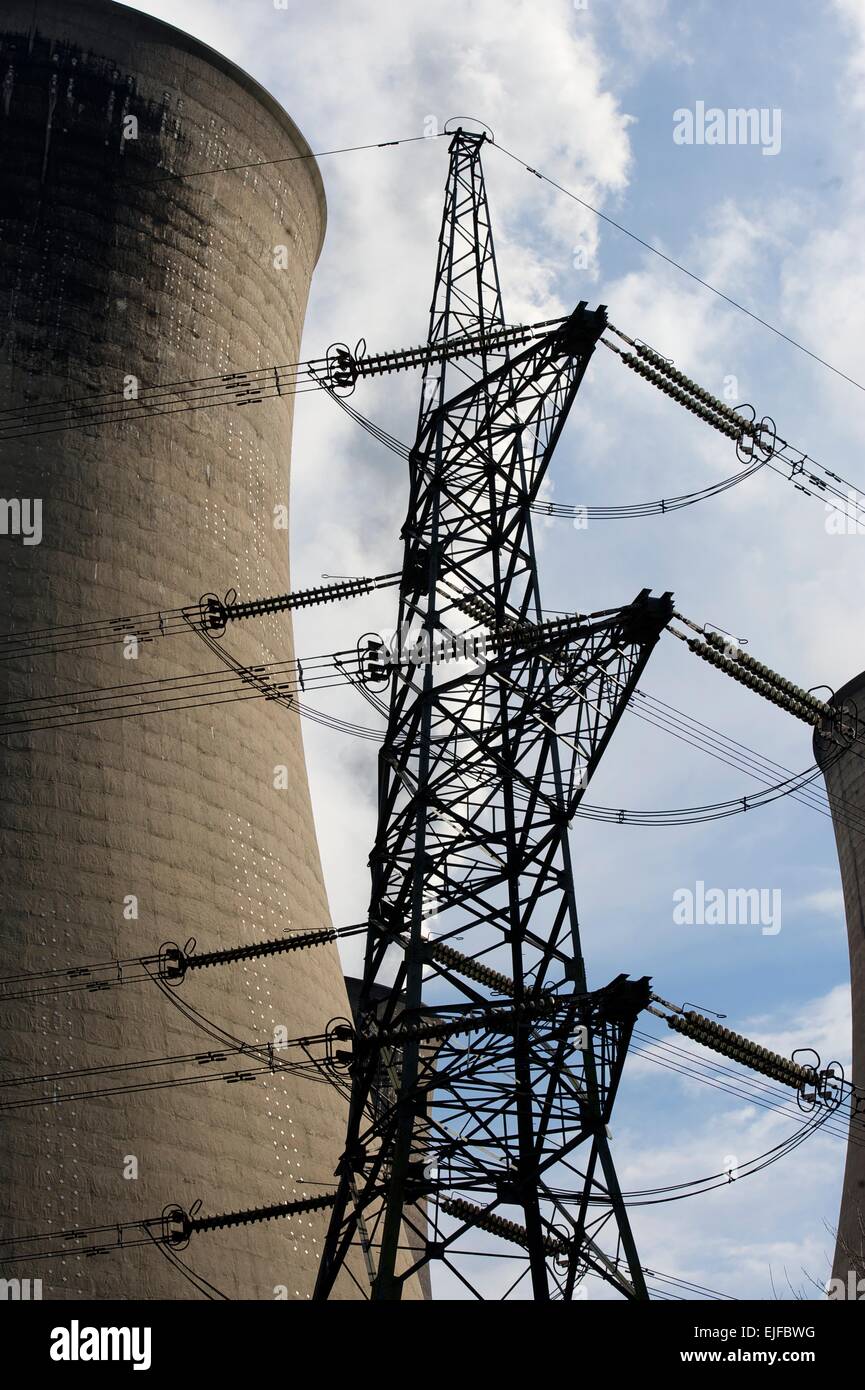 Cooling towers and electricity pylons against a bright cloudy sky at ...