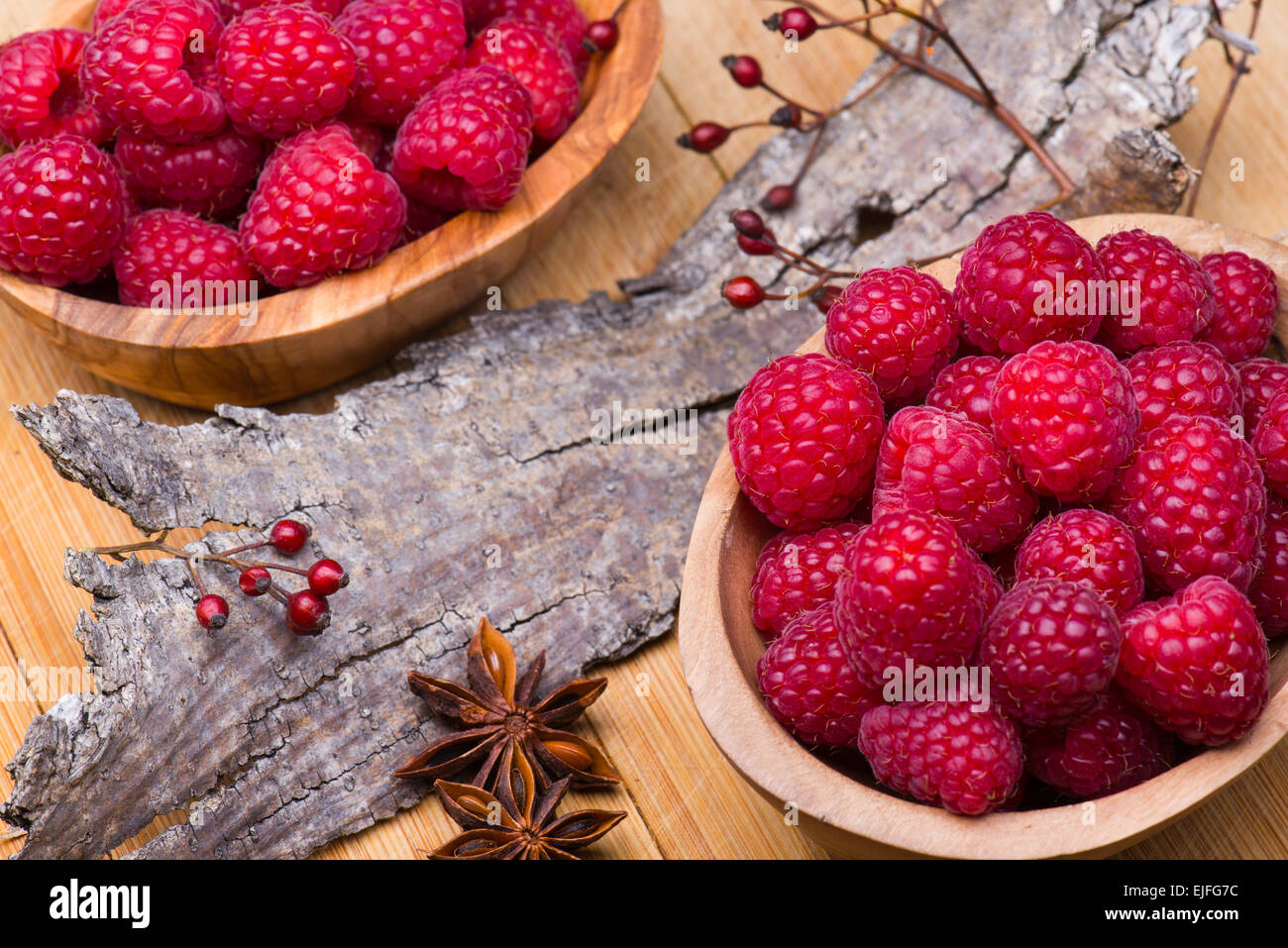 Bunch of raspberries in wood bowl on wood and bark background Stock ...