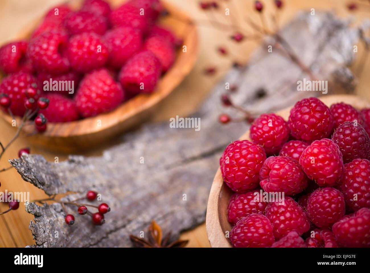 Bunch of raspberries in wood bowl on wood and bark background Stock ...