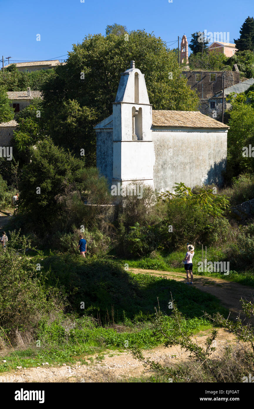 Tourists by Church of Saint Spiridon with belltower in ancient village ...