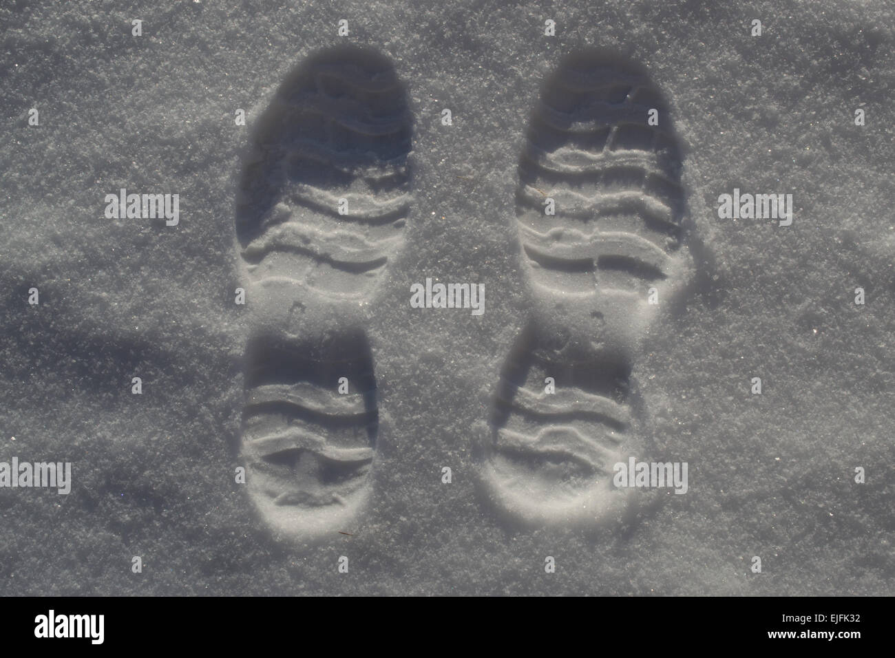 Two bootprints in winter snow signalling the start of a journey Stock ...