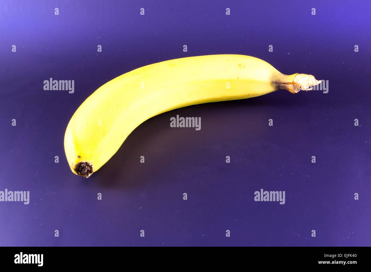 A single yellow banana fruit on blue isolated background Stock Photo ...