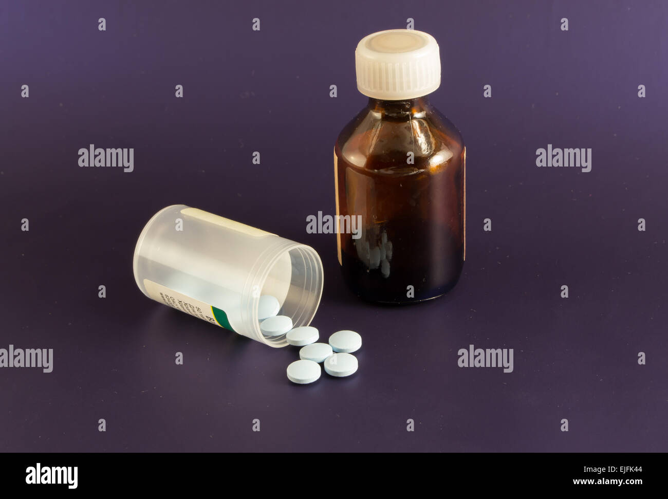 Blue medcine tablets and brown glass bottle on blue background Stock ...