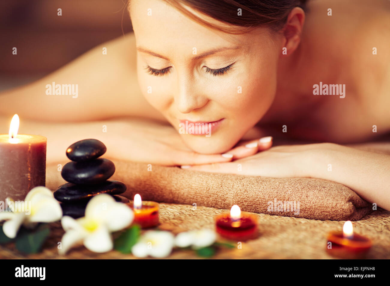 Woman relaxing among candles and flowers Stock Photo - Alamy