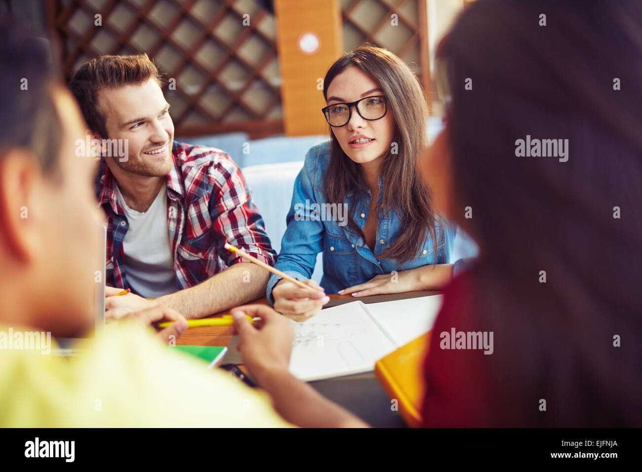 Girl in glasses explaining topic to friends Stock Photo - Alamy