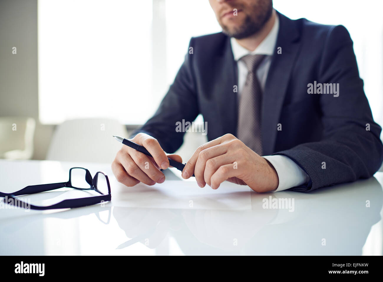 Man with pen thinking about work Stock Photo - Alamy