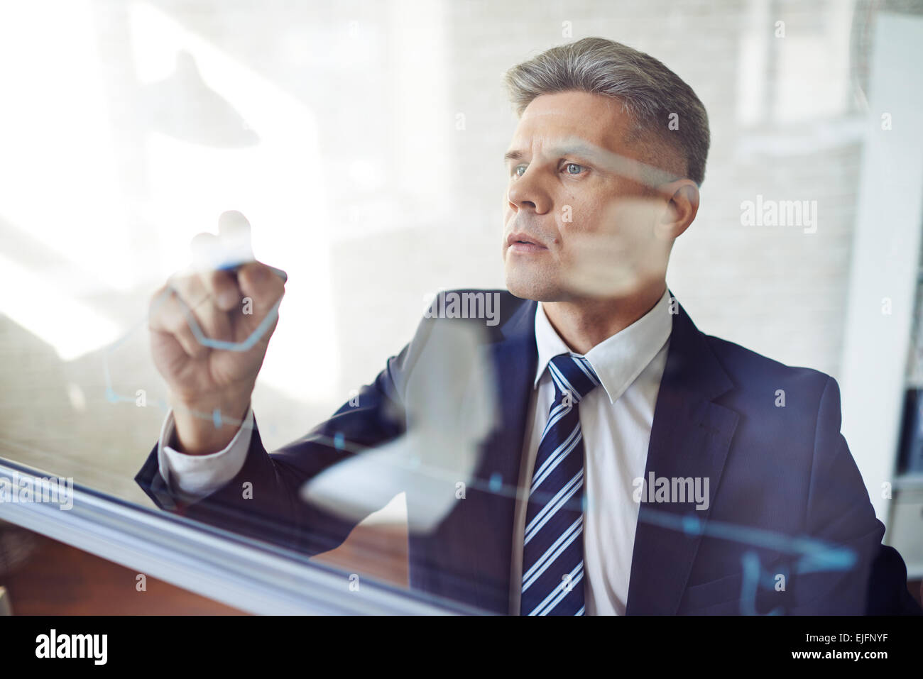 Concentrated man writing graph Stock Photo - Alamy