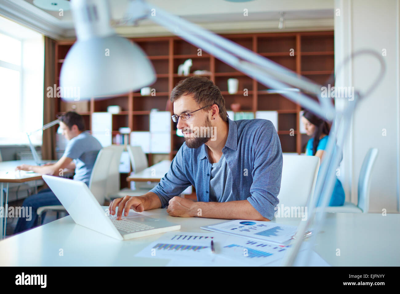 Young man using laptop in office Stock Photo - Alamy