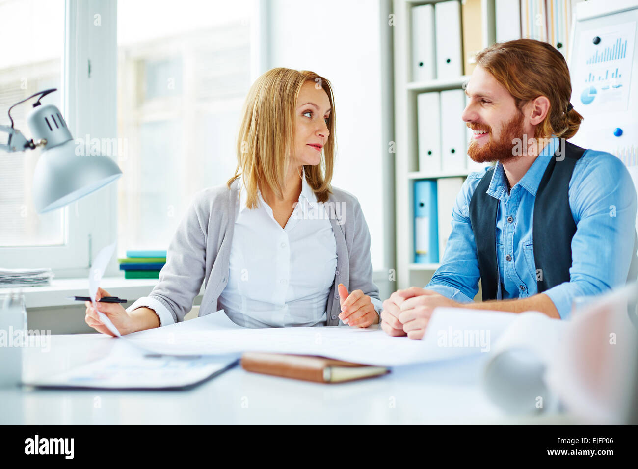 Two business people talking in office Stock Photo - Alamy