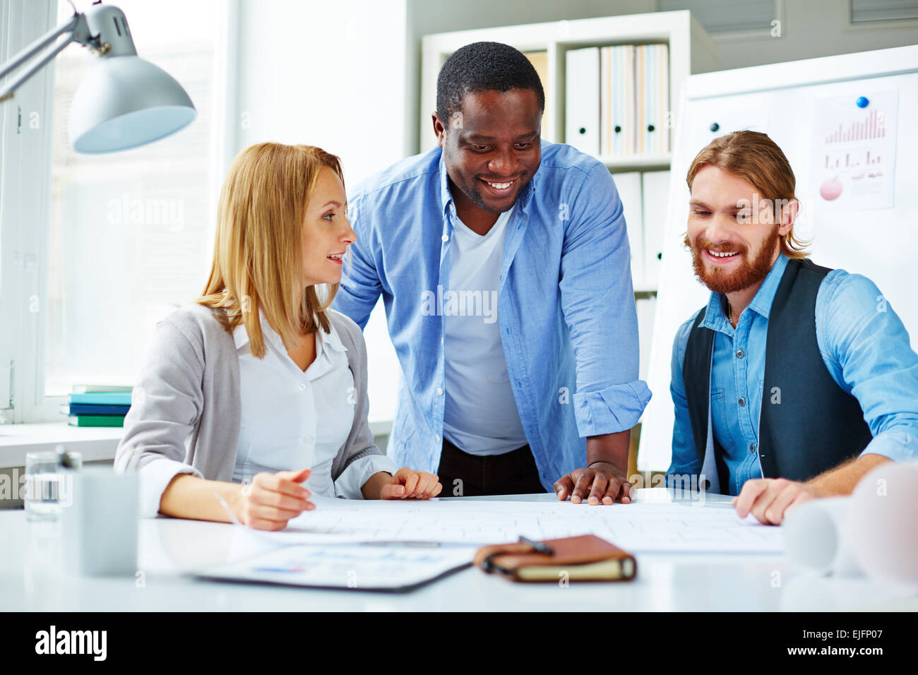 Three business people planning over blueprint Stock Photo - Alamy