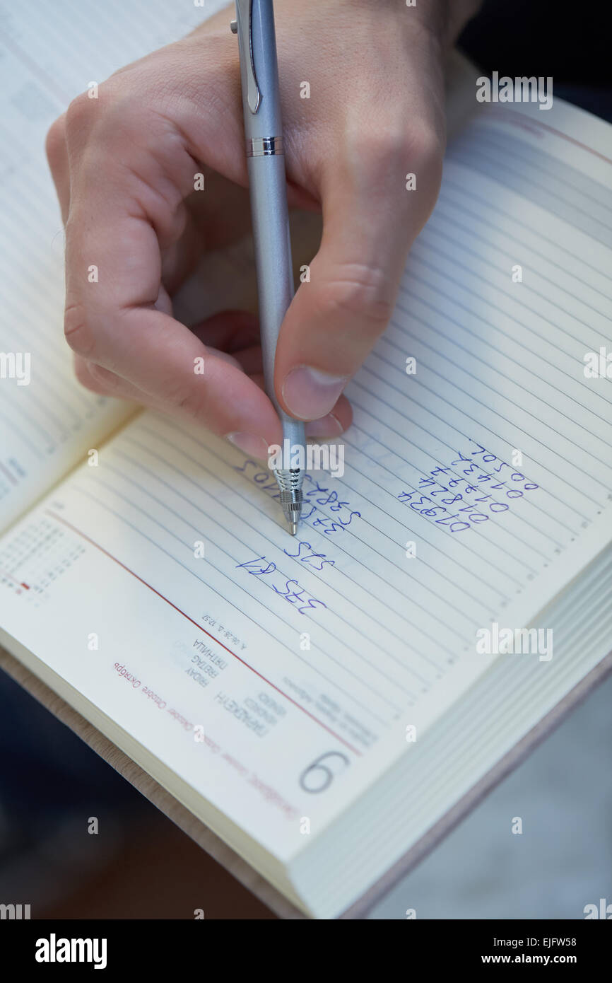 man writes in datebook Stock Photo - Alamy