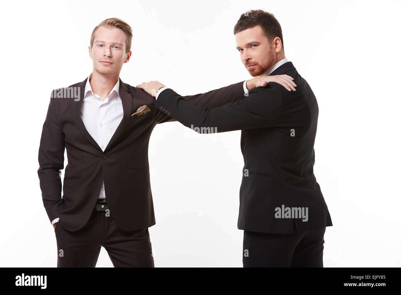 Two young men in suits talking having fun Stock Photo - Alamy