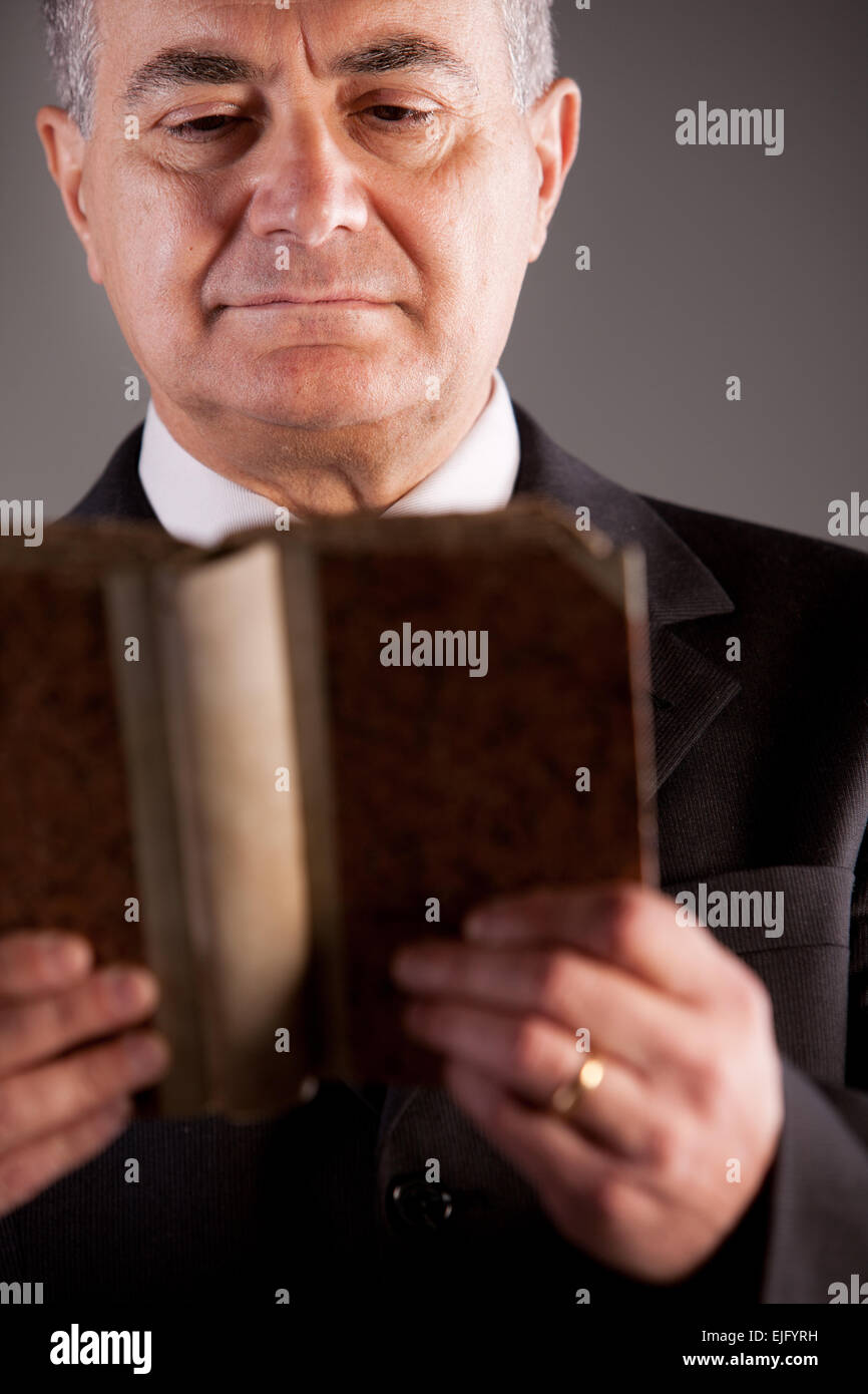 mature man in suit reading an ancient book Stock Photo - Alamy