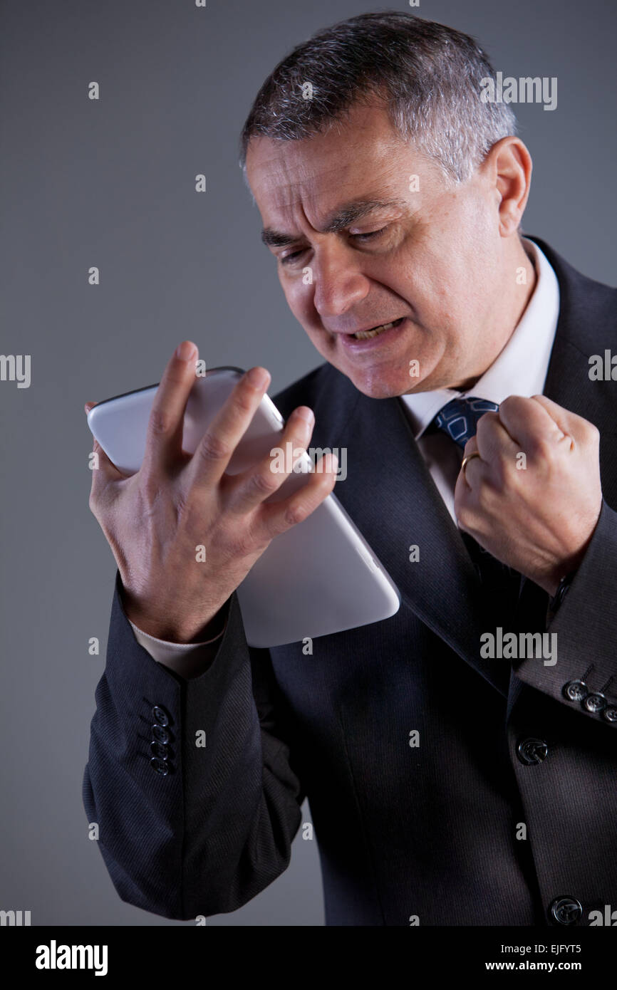 an old man angry with a malfunctioning tablet Stock Photo - Alamy