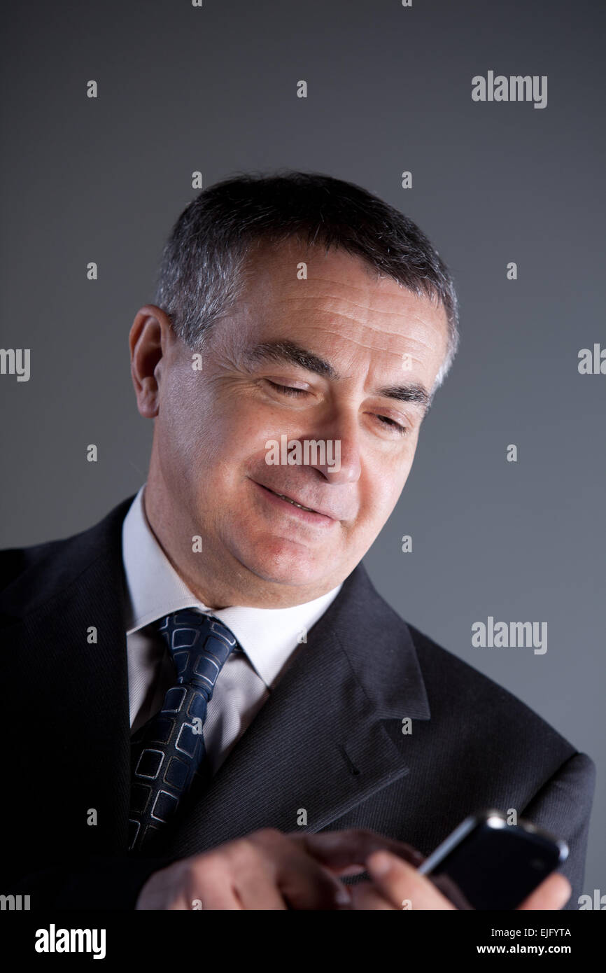 old man using a smartphone on a neutral background Stock Photo - Alamy