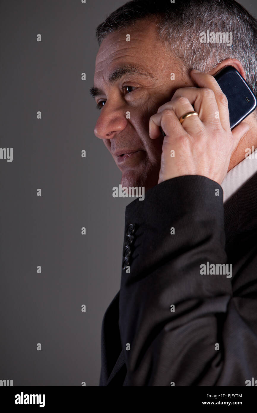 old man using a smartphone on a neutral background Stock Photo - Alamy