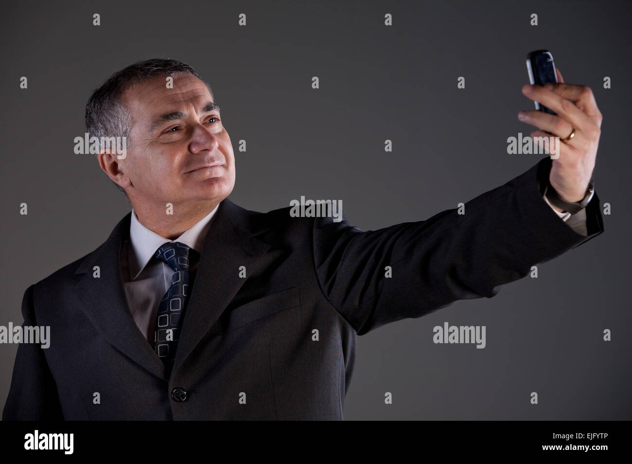 old man using a smartphone on a neutral background Stock Photo - Alamy