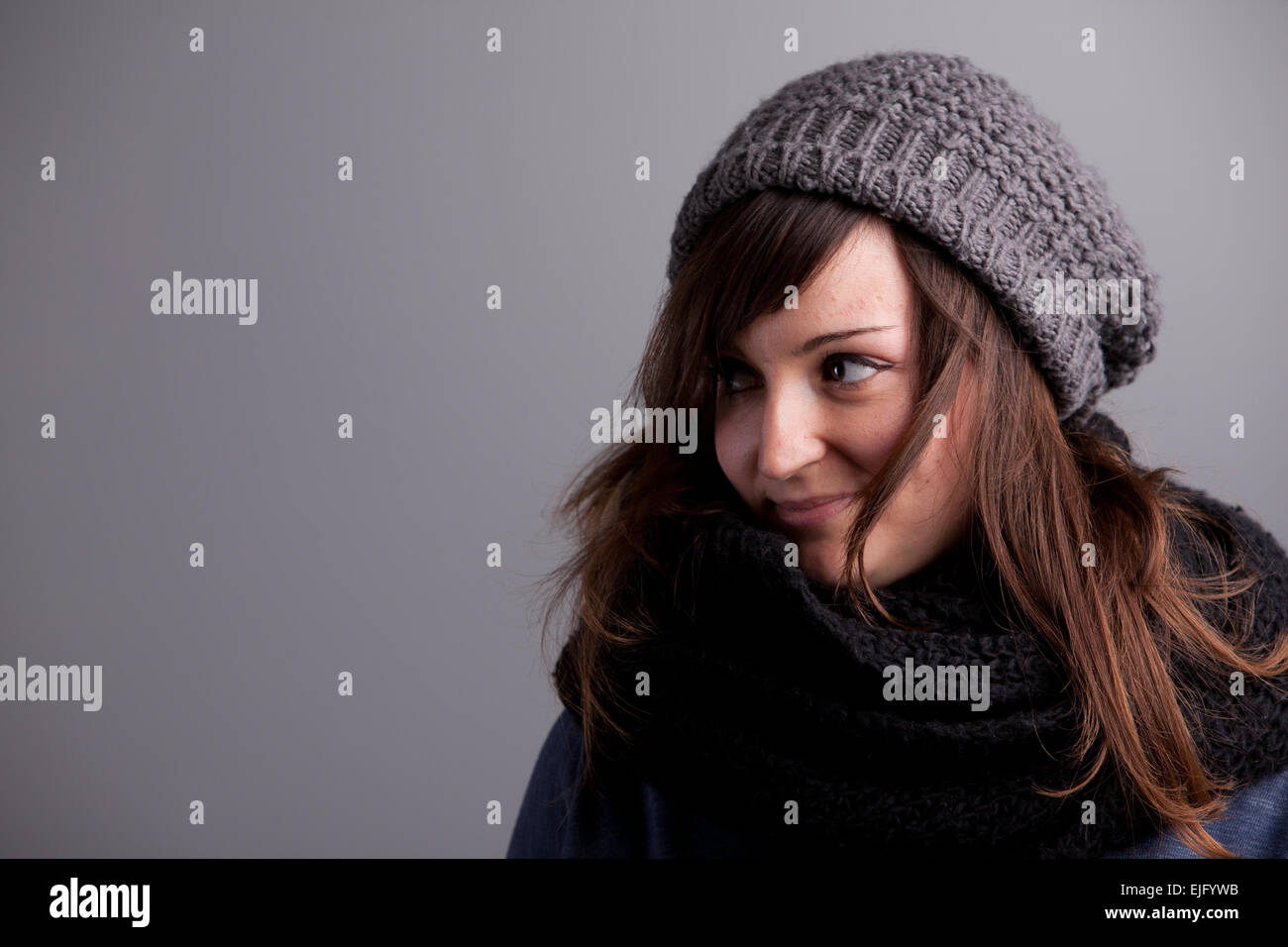woman looking left with hat and scarf on a neutral background Stock ...