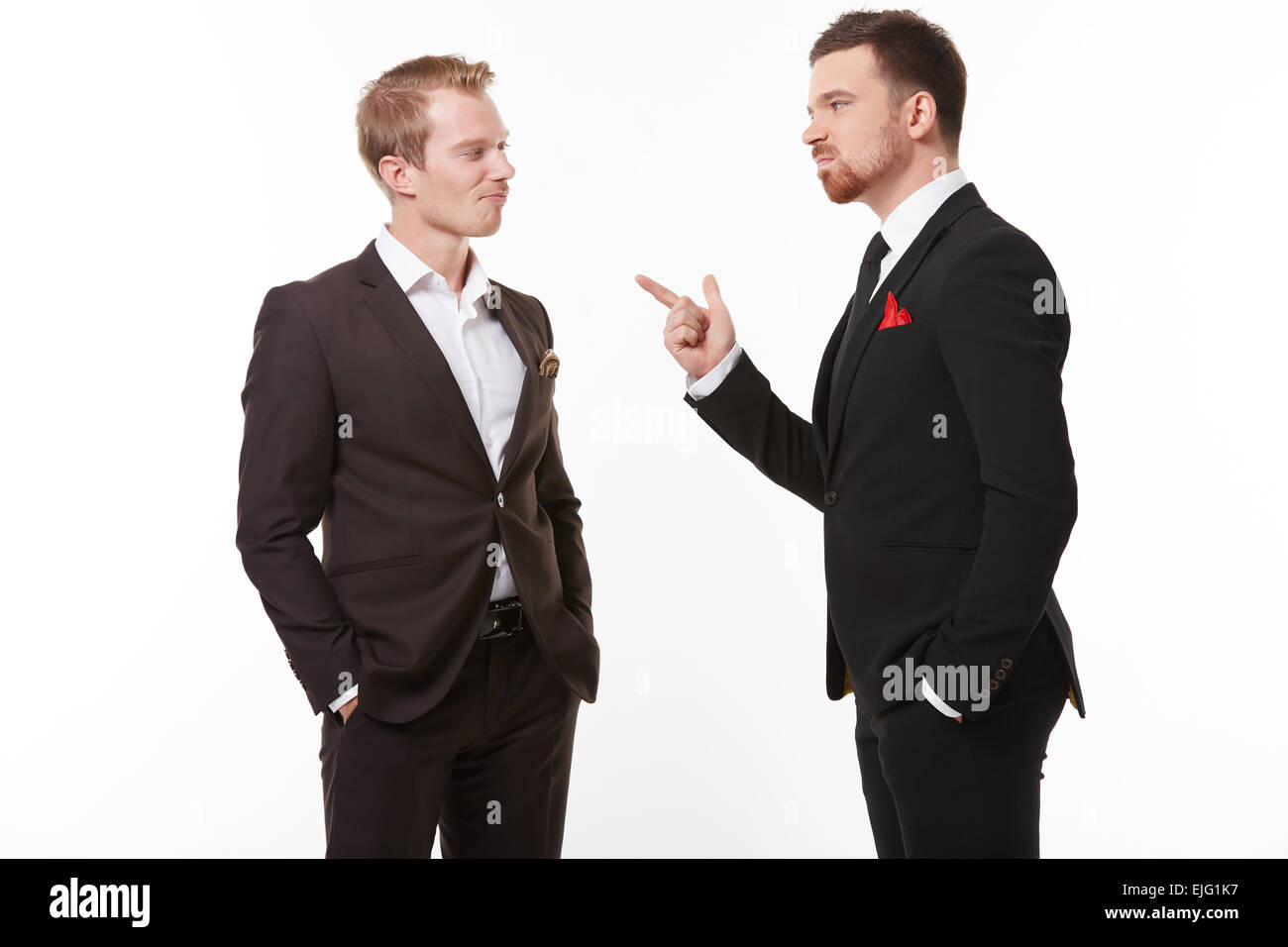 Two young men in suits talking having fun Stock Photo - Alamy