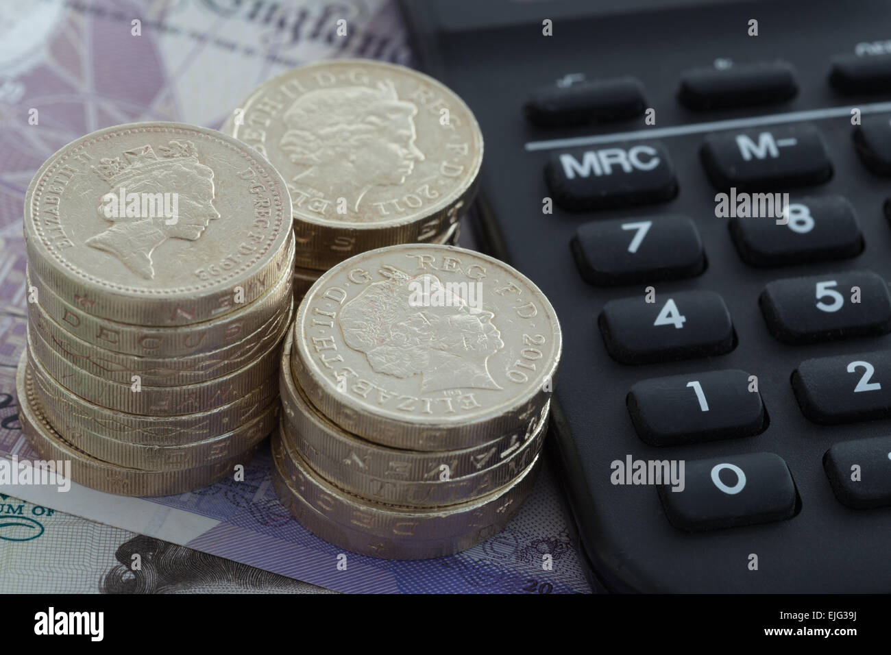 close up of stacks of coins next to a black pocket calculator Stock ...