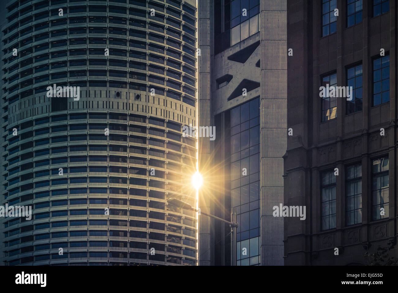 Bright sunrays shining between two tall buildings in a financial ...