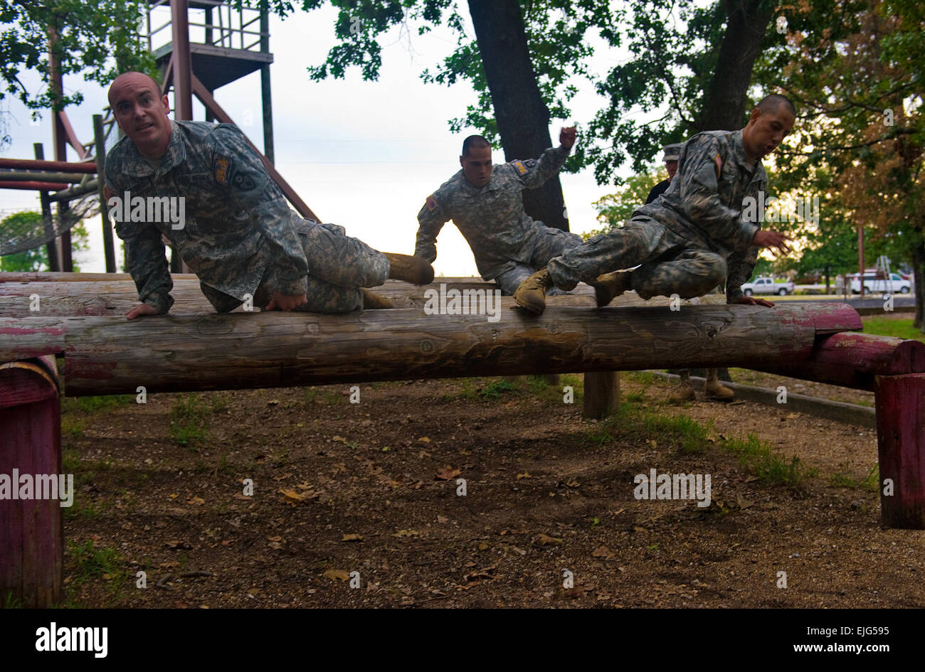 Competitors in the Army Warfighter Challenge hurdle over a series of ...