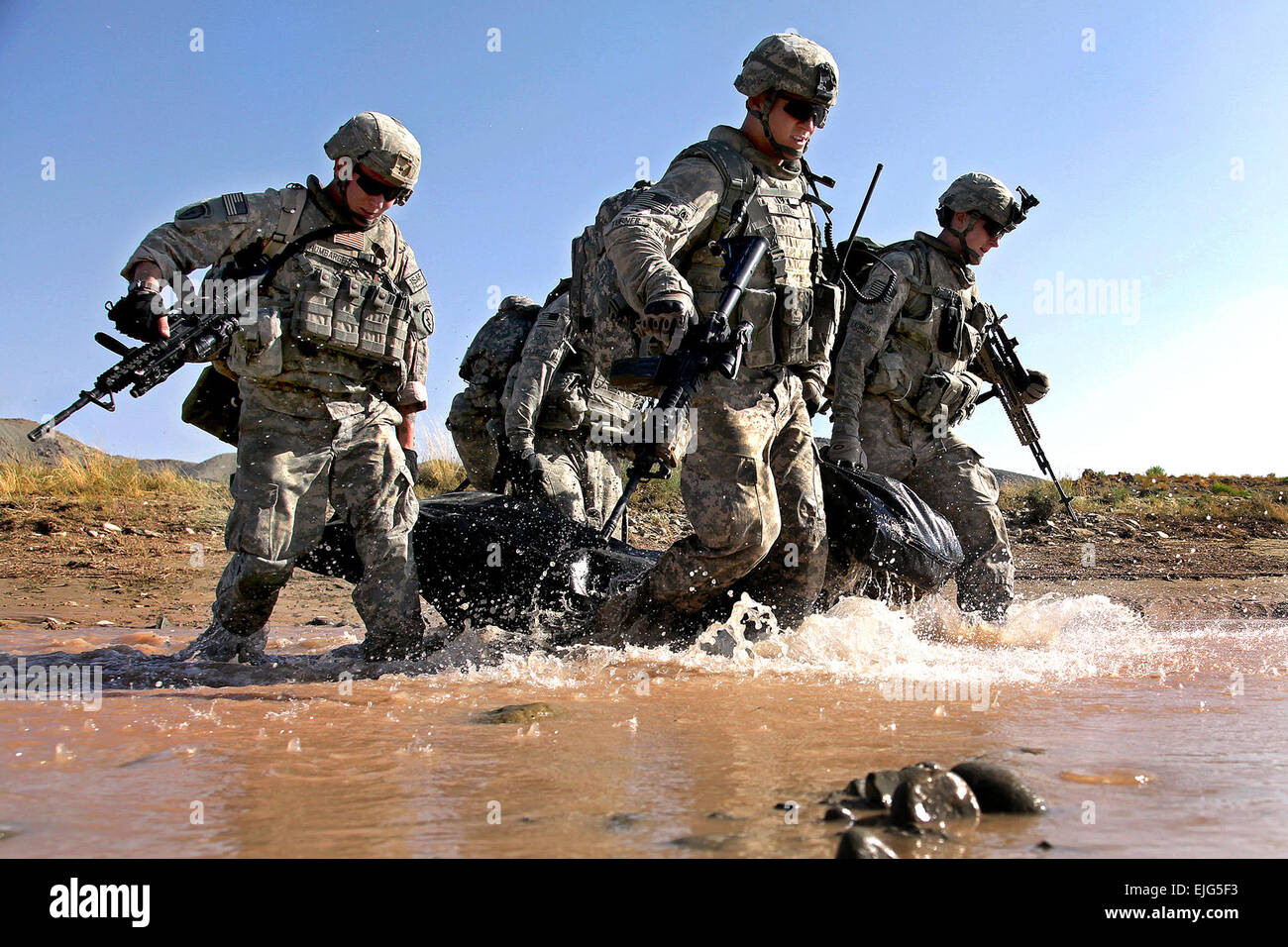 U.S. Army Soldiers carry a bag filled with food and water that will ...