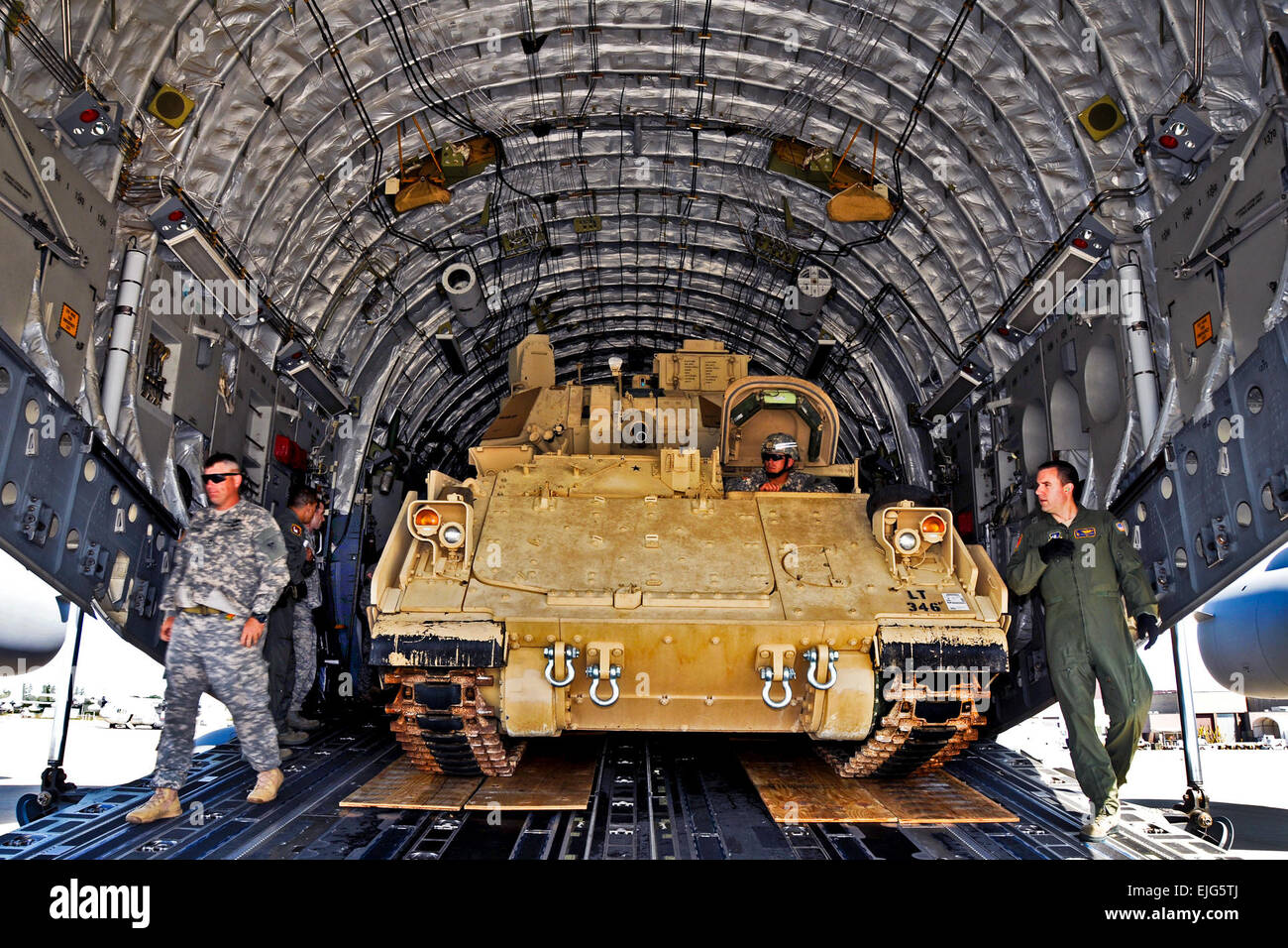 A Soldier backs an M32 Bradley fighting vehicle into a C-17 cargo bay ...