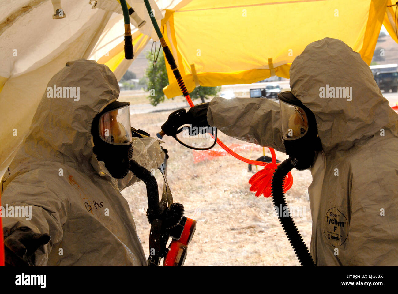 U.S. Army Spc. Brian Thomas rinses contaminates off of Staff Sgt ...