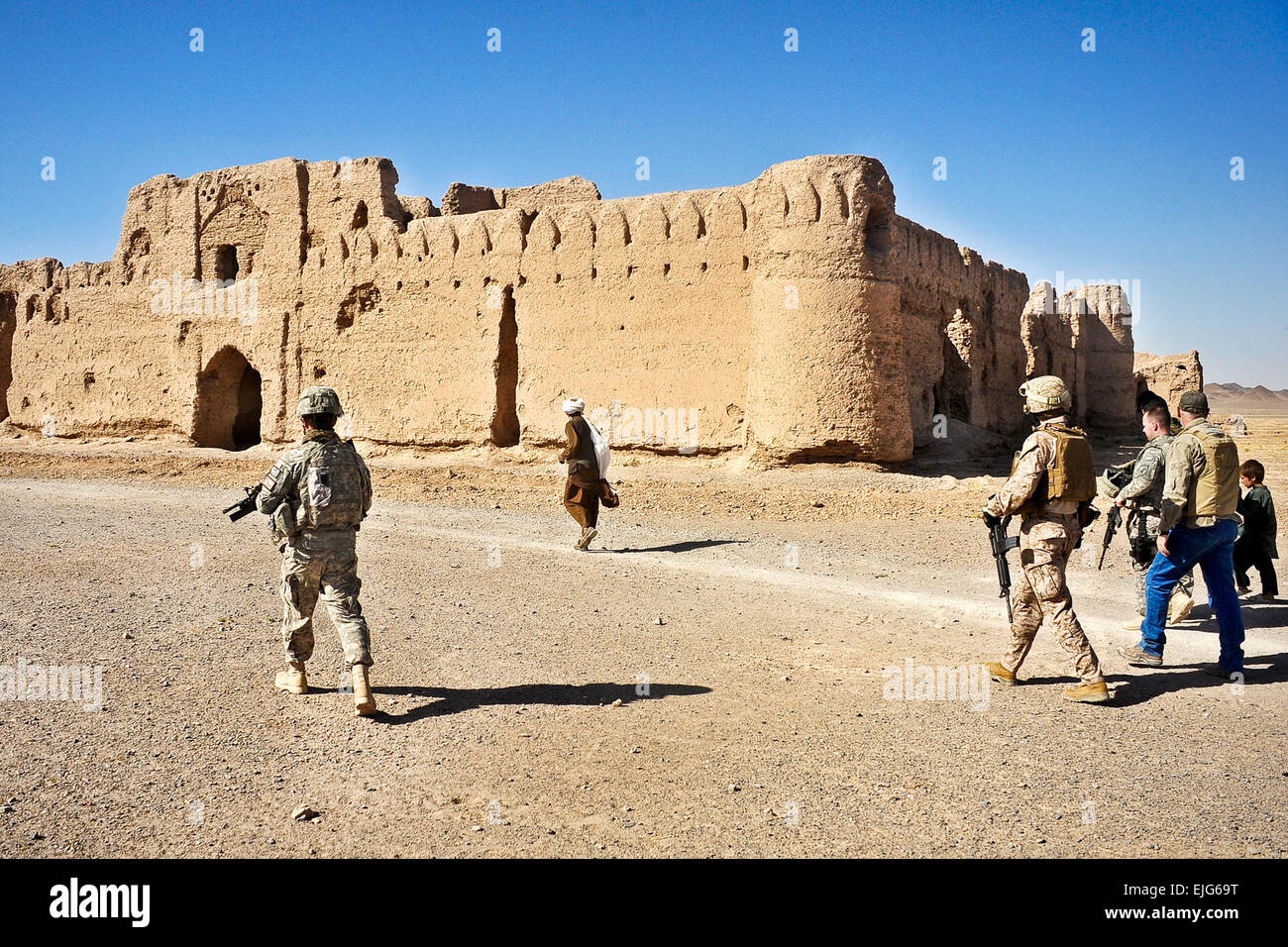 U.S. soldiers walk near a historic castle with members of the Kuchi ...