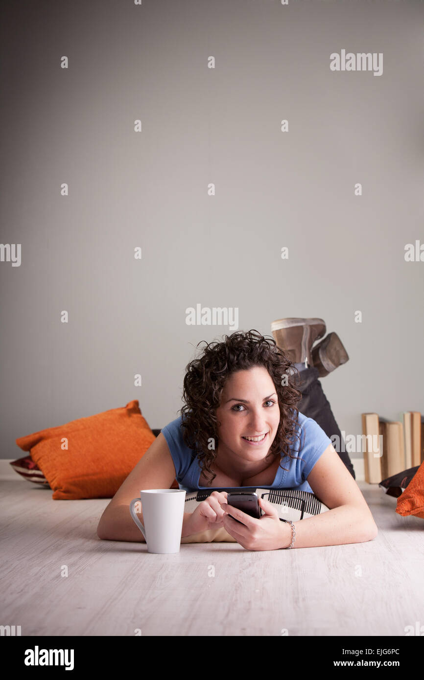 girl enjoying her mobile phone while drinking from a white mug Stock ...