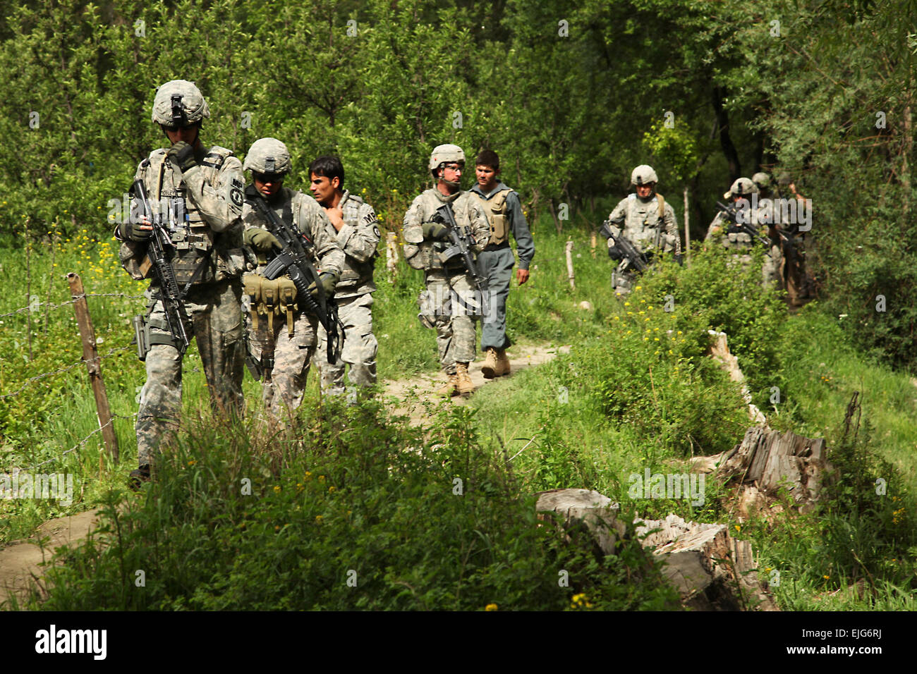U.S. Army Soldiers and Afghan national police officers walk down a path ...
