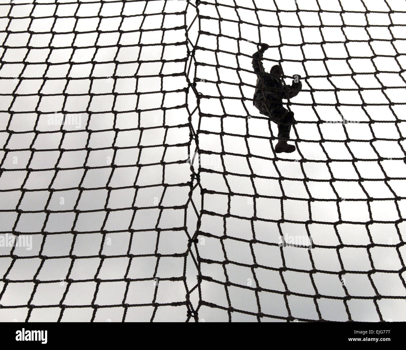 A Soldier trainee makes her way down the rope ladder obstacle during ...