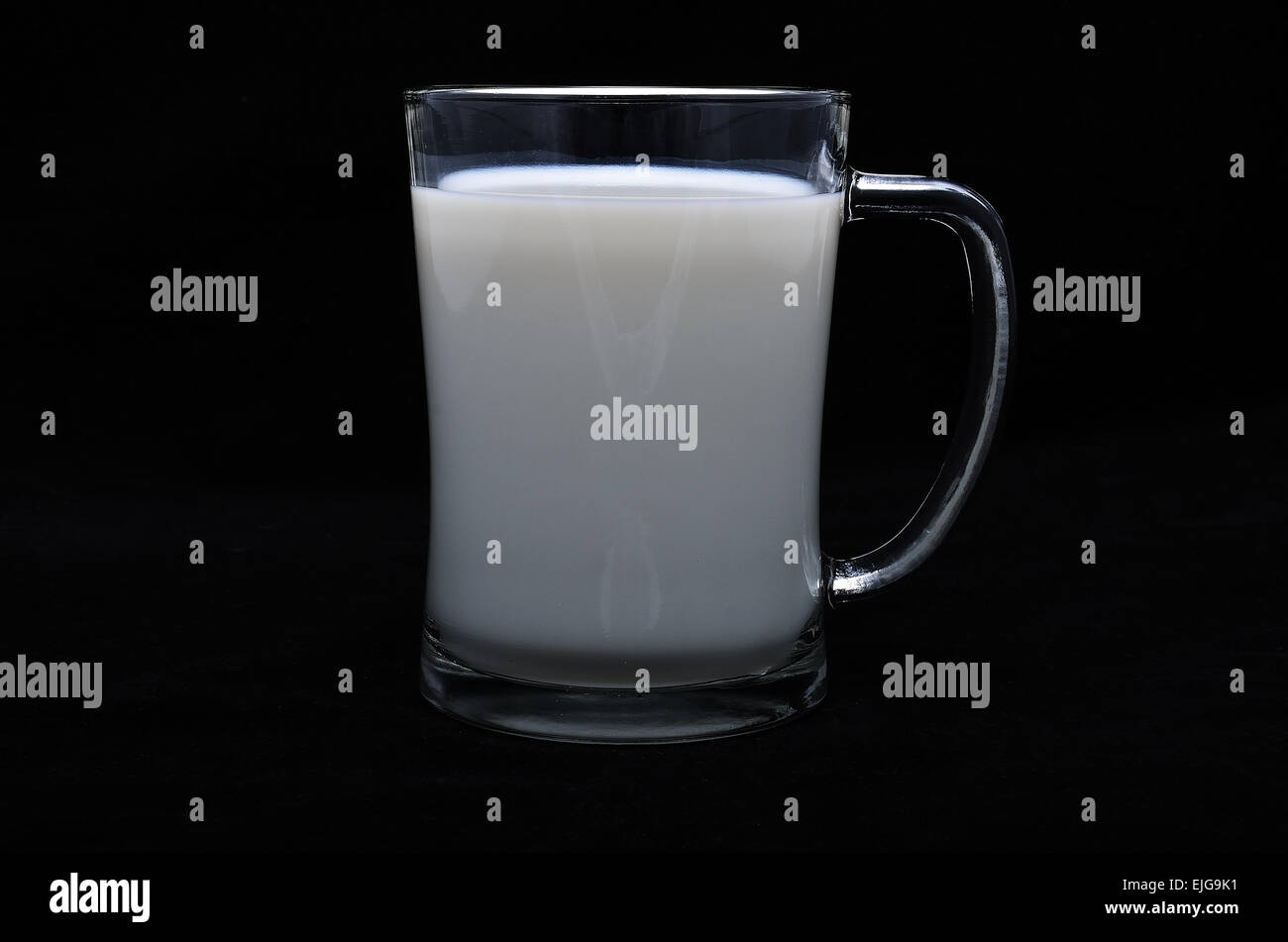 A beer mug is filled with milk isolated on a black background Stock ...