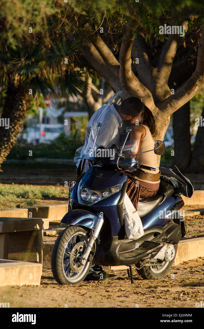 A twosome kissing on a bike in the park Stock Photo - Alamy