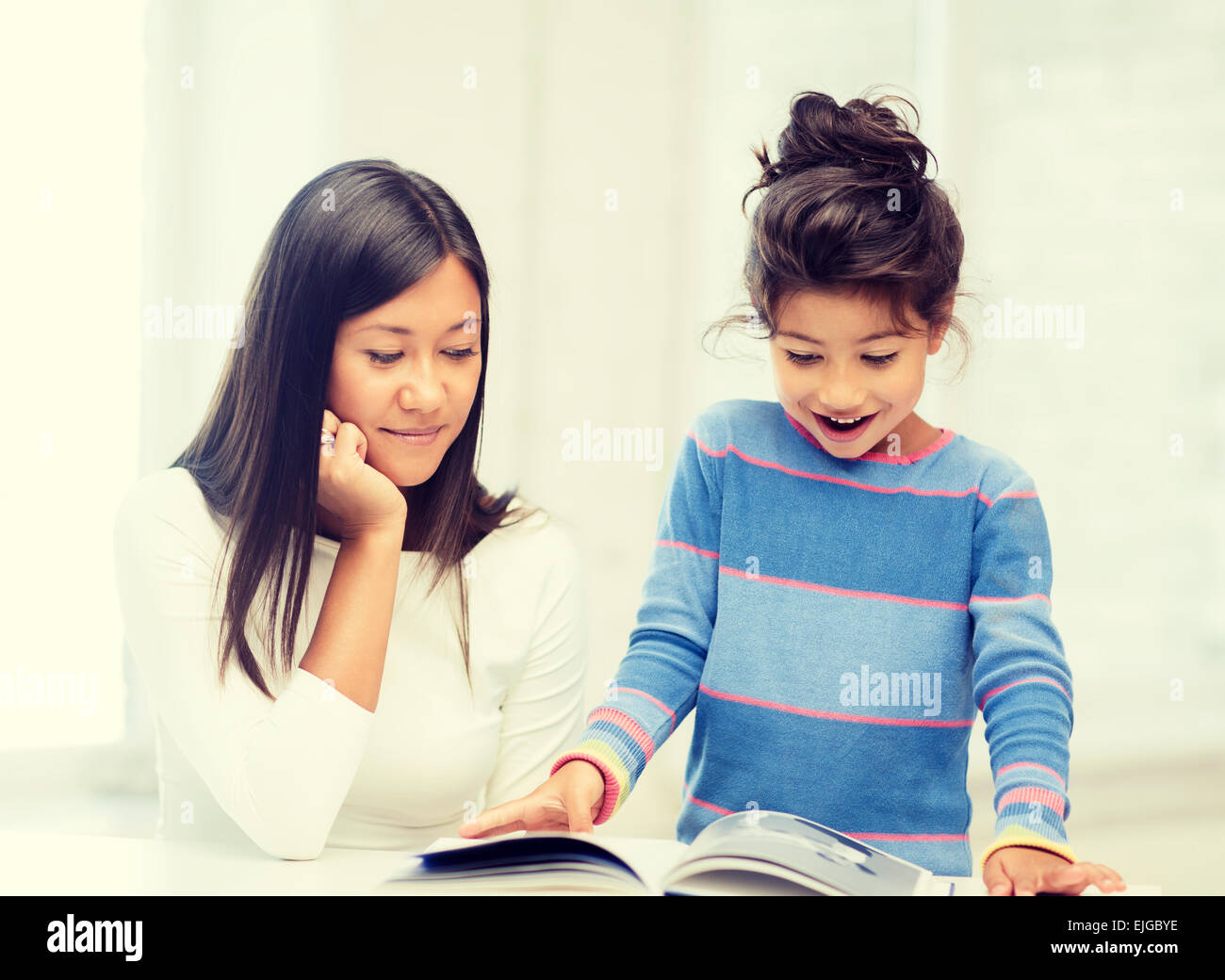 mother and daughter with book Stock Photo - Alamy