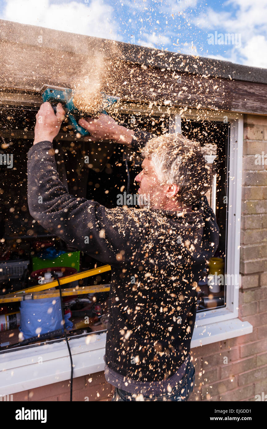 A Carpenter using an electric planer to plane some wood Stock Photo - Alamy