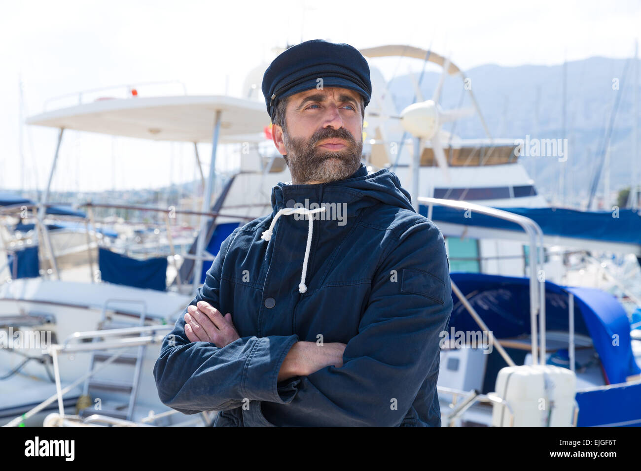Sailor man in marina port with boats background and blue cap Stock ...